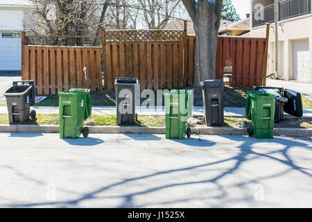 Emptied household green bins and garbage bins are left on the street ...