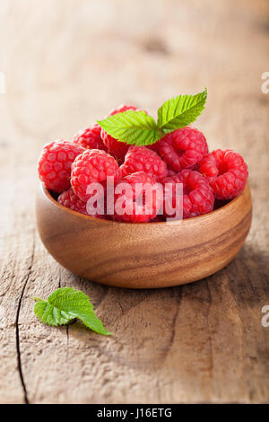 Raspberries in a bowl over wooden table Stock Photo - Alamy