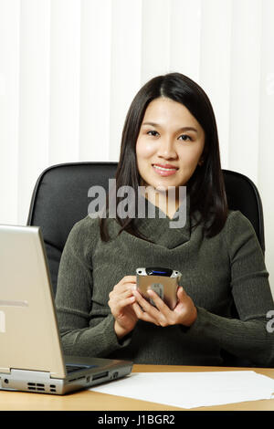 Beautiful Asian businesswoman working with a PDA on white background ...