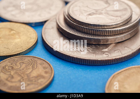 Different kinds of coins over a blue background. Macro detail ...