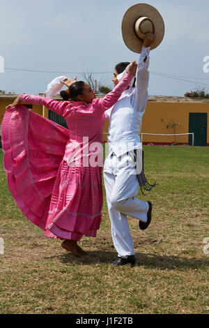 Lady in pink dress dancing a traditional folk dance with a Peruvian ...