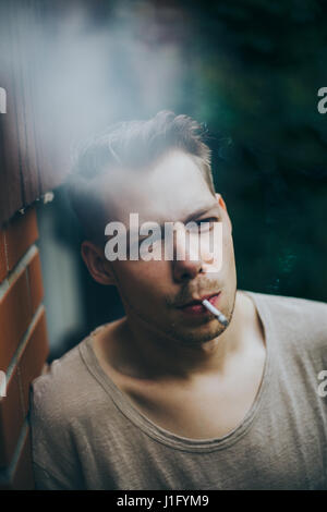 A vertical portrait of a young caucasian smoking female with colored ...