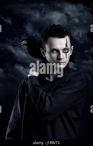 Spooky man with crow on night city background. Halloween concept Stock ...