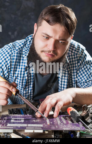 Repairman fixing problem with electronic components of computer ...