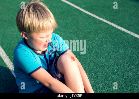 Boy child with bleeding knee wound Stock Photo - Alamy