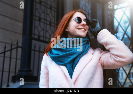Lady in light blue coat walks down the entrance path towards the ...