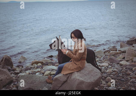 Side view of owner using smartphone near clothes in carton box in ...