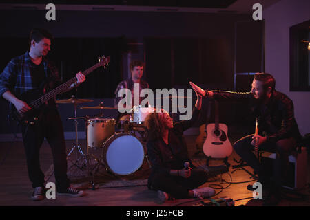 Band mates giving high five to each other in recording studio Stock ...