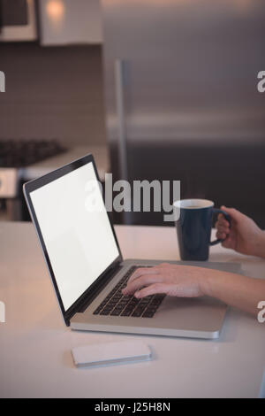 Cropped image of woman holding mug with word relax on it on a couch ...