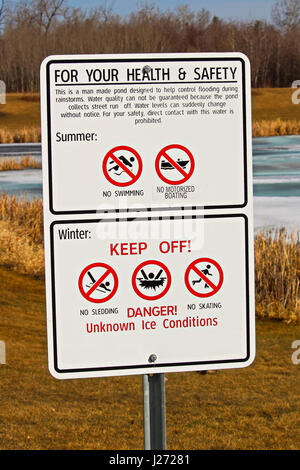 Warning signs around storm drainage pond Stock Photo - Alamy