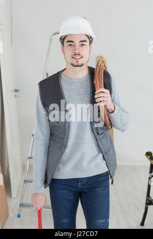 Portrait of man with reel of copper pipe Stock Photo - Alamy