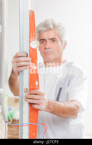 Mason using an orange spirit level Stock Photo - Alamy