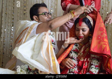 The groom applies sindoor or vermilion to the bride as a symbol of ...