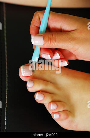 cuticles being pushed back during pedicure Stock Photo - Alamy