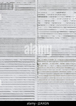 A vertical shot of a snow-covered field with spruces and a wooden home ...