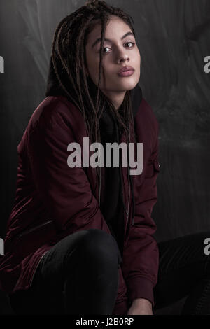 beautiful model with black jacket on outside with flowers background ...