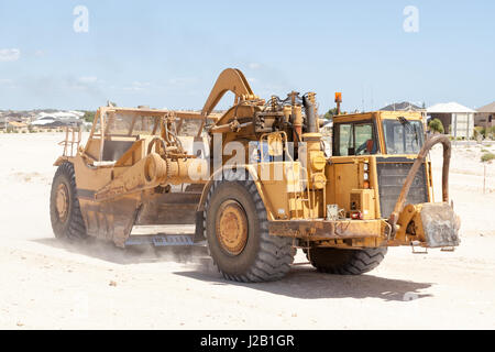 Earth moving machines on site digging a hole in the ground for a ...