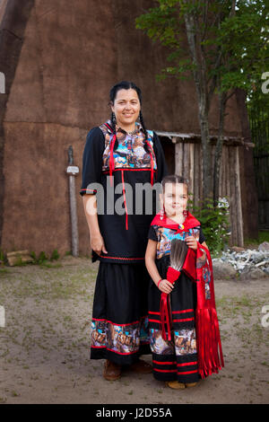 Ojibwe mother and daughter dressed in traditional ribbon dresses with a ...