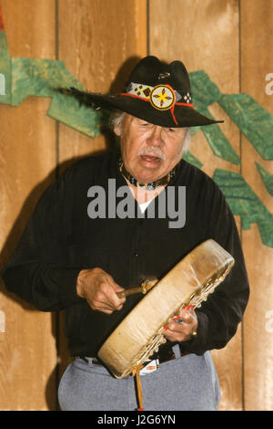 Athabaskan man sings traditional songs and plays a hand drum during a ...