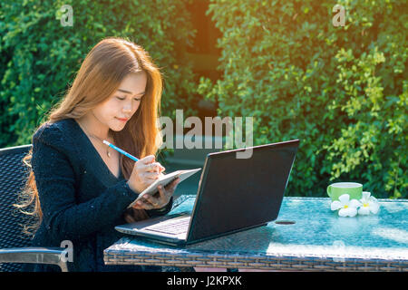 Young woman used a pencil to write notes with laptop Stock Photo - Alamy