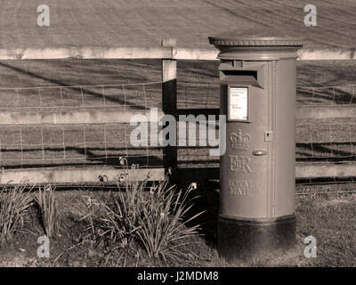 Sepia Royal Mail postbox in countryside rural setting with village ...