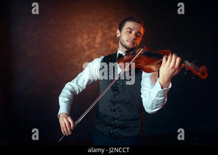 Portrait of male fiddler playing classical music on violin. Violinist ...