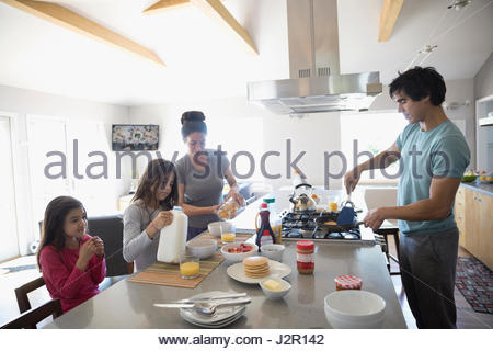 family in kitchen making breakfast together. small girl have fun with ...