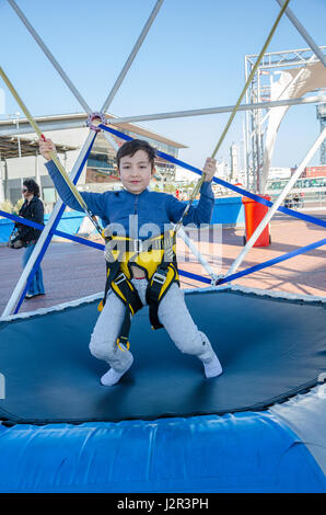 Young boy on bungee bounce swings at safety harness and ropes Stock ...