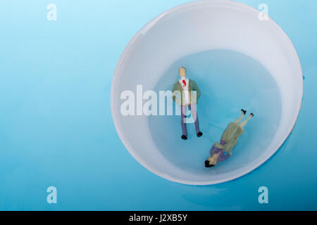 Little model globe with figurines floating in blue water Stock Photo ...
