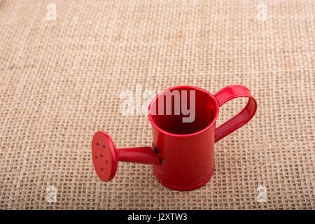 Watering can on a canvas background Stock Photo - Alamy