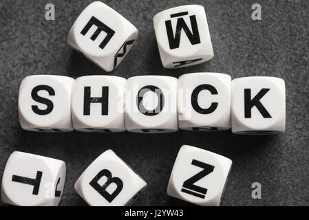 Alphabet letters spelling the word shock and a wooden toy ambulance ...