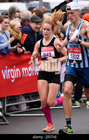 Athletes running in the London marathon event on a paved city road ...