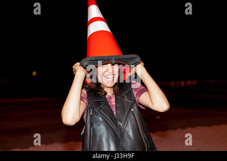 Playful young woman with a traffic cone on her head Stock Photo - Alamy