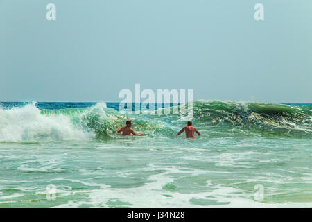 Two men dive into the waves of the Indian Ocean Stock Photo - Alamy