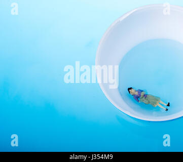 Little model globe with figurine floating in blue water Stock Photo - Alamy