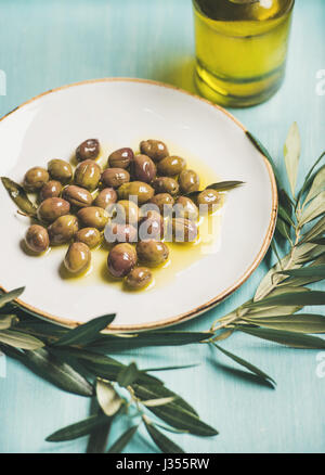 Vertical selective focus of a branch with green leaves on blurred lake ...