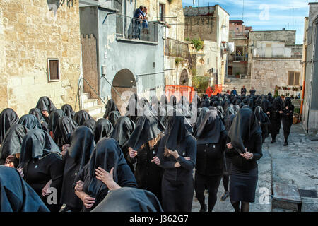 The women dressed in black parading arm in arm along the streets of ...