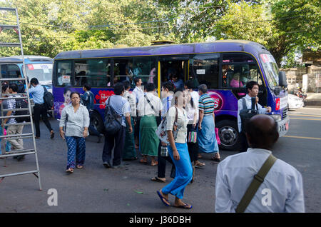 Myanmar, Burma. Yangon, Bus Stop on Sule Pagoda Road. The man and woman ...