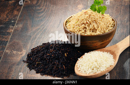 Composition with bowl of rice on wooden table Stock Photo - Alamy