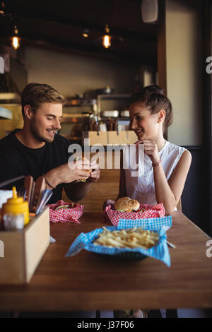 Happy couple interacting while fast food Stock Photo - Alamy