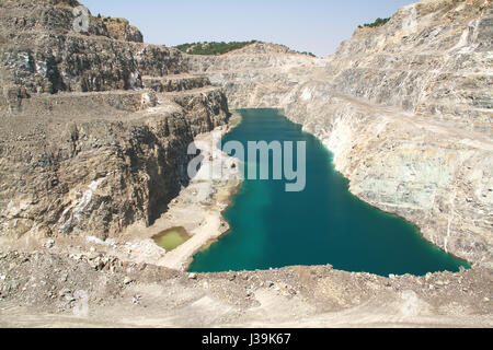An abandoned open-pit coal mine is filled with water. The mine is in ...