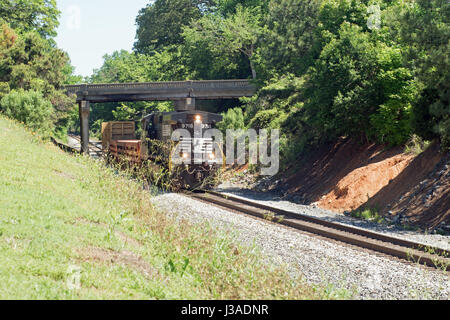 Freight train coming down the tracks next to a soybean field that is ...