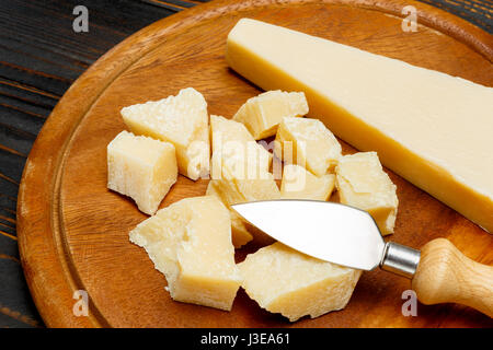 Parmesan cheese and knife on a wooden cutting board Stock Photo - Alamy