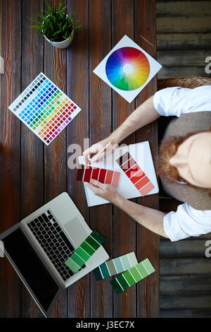 Graphic designer working with color palettes and digital tools in a ...
