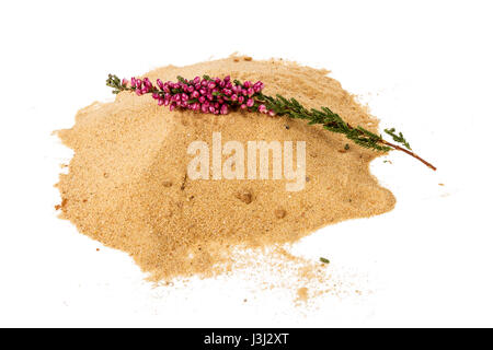 Pile of yellow sand and common heather twig isolated on white ...