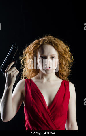 Beautiful redhead young woman with gun and military outfit, isolated on ...