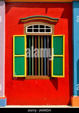 Traditional Indian window with colorful shutters in an orange wall of a ...