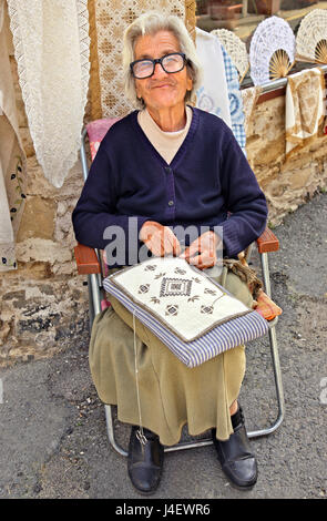 Old woman embroidering lefkaritika (traditional handmade lace) next to ...