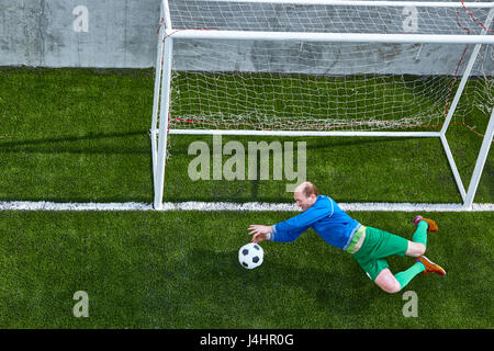 Soccer football goalkeeper making diving save Stock Photo - Alamy