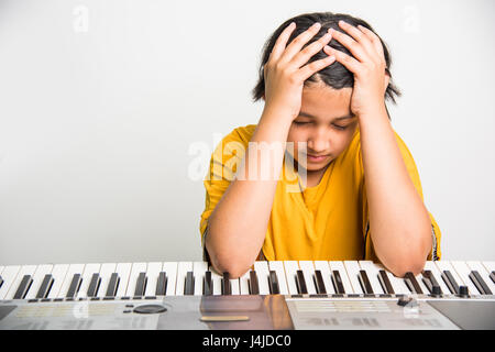indian kids playing piano or keyboard, a musical instrument, isolated ...